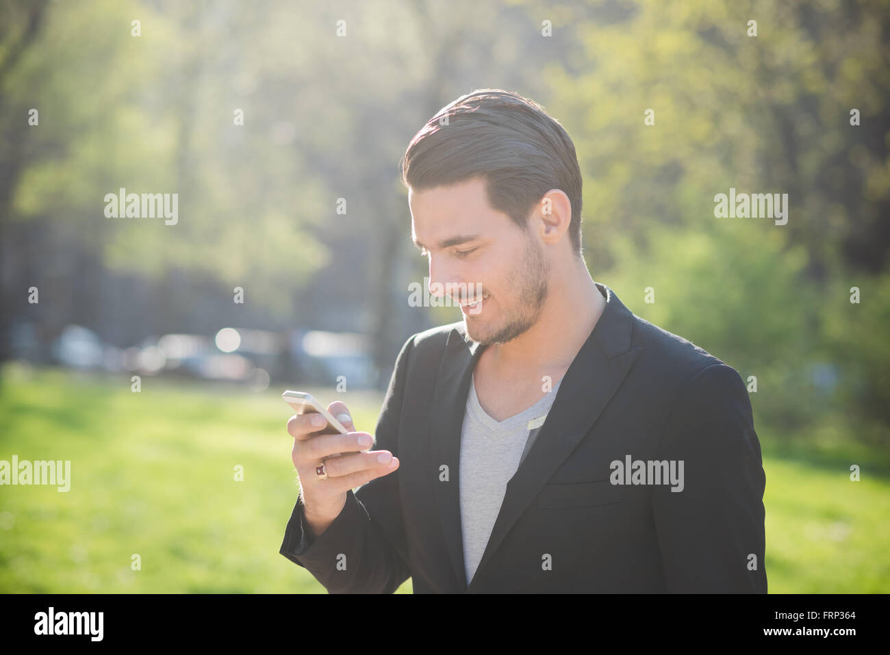 Portrait of a young handsome caucasian man using a smart phone ...