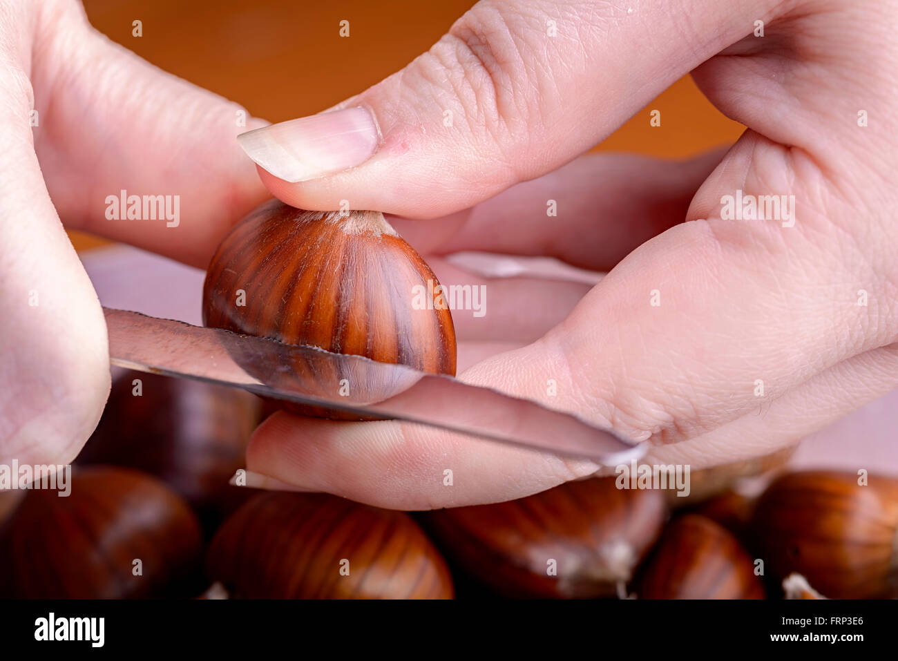hand cutting a chestnut with a knife Stock Photo - Alamy