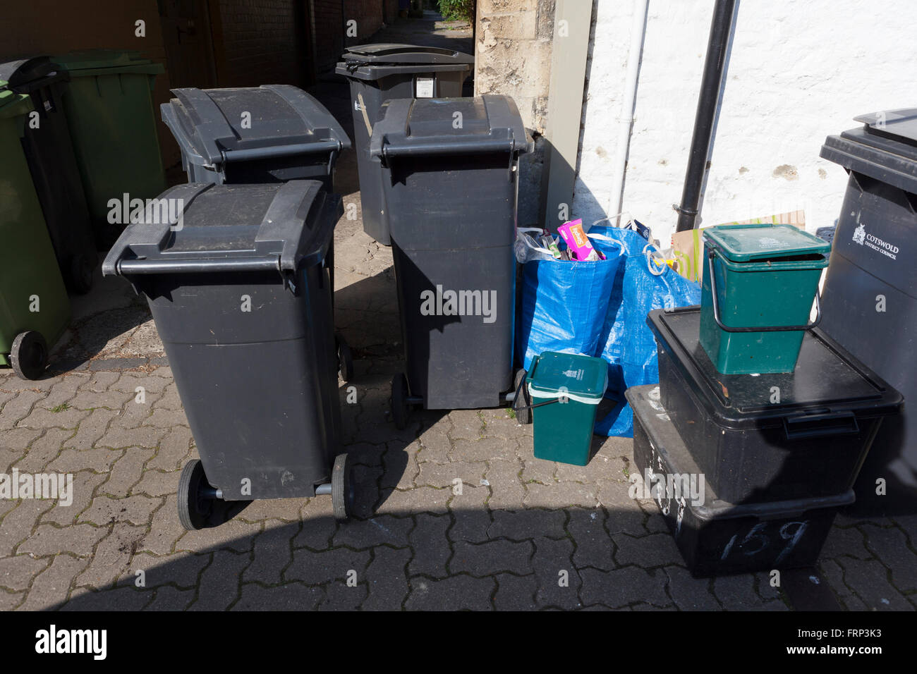 Assorted waste containers on the road side. Bins buckets and bags stand ...