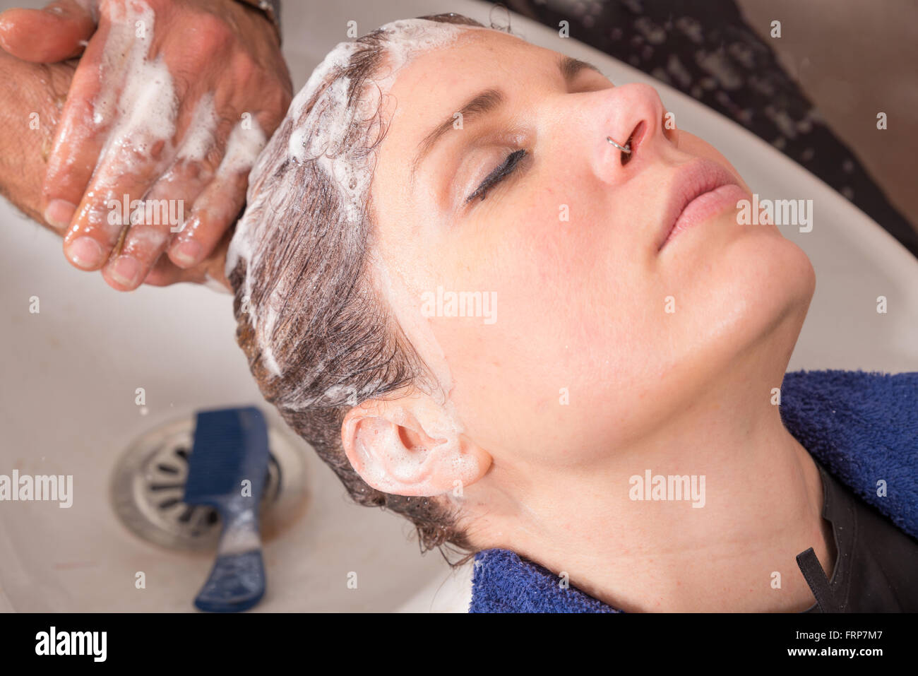 Hair stylist shampooing hair of a female customer Stock Photo - Alamy