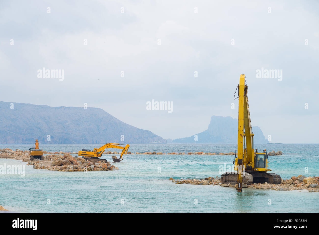 Large diggers working on a coastal dam Stock Photo - Alamy