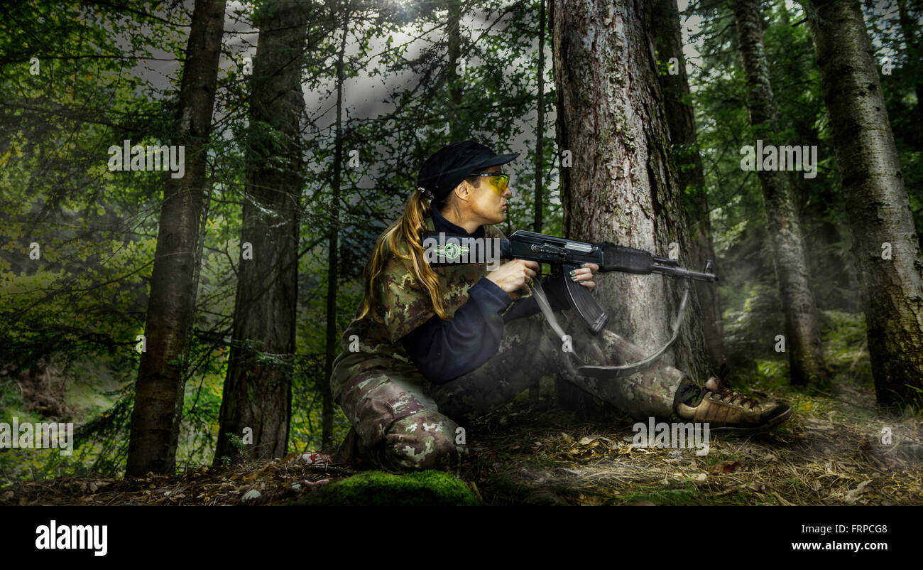 Girl in a military uniform with a rifle in the hands Stock Photo - Alamy