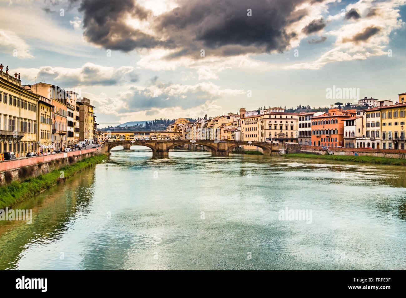 historic buildings overlooking the Arno river that flows peacefully ...