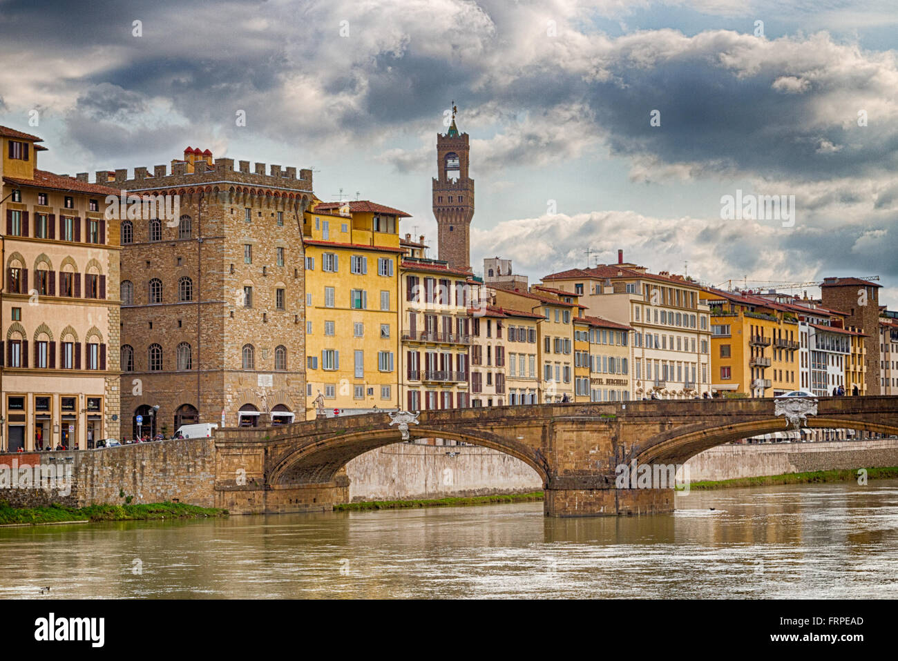 historic buildings overlooking the Arno river that flows peacefully ...