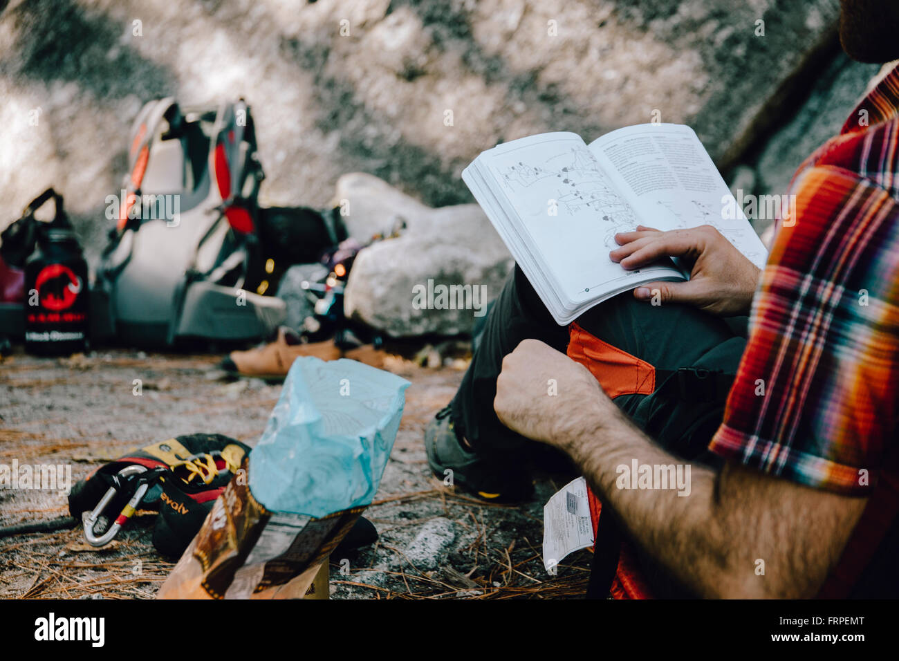 A climber reading the guide book at the base of Hanging Flake (5.6) in ...
