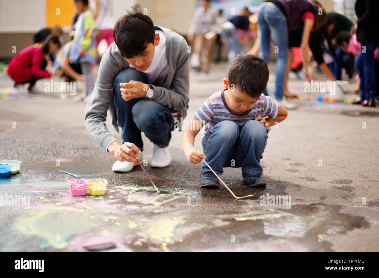 Children painting on the ground Stock Photo - Alamy