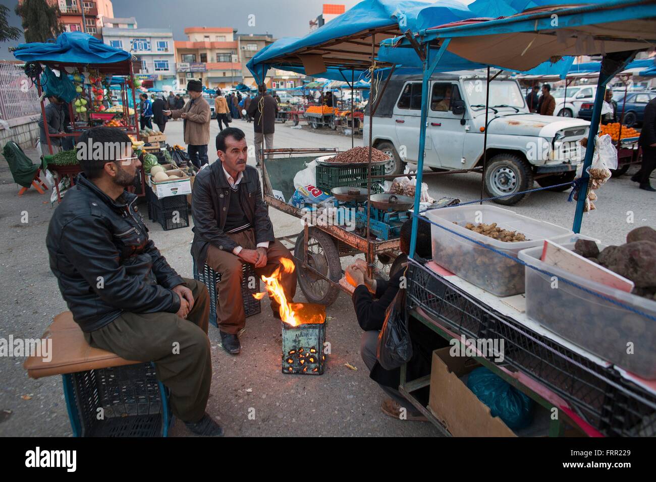 street vendors stay warm at a fire at the market in Kalar, Iraq Stock ...