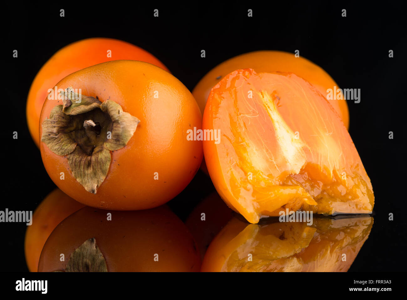 Persimmon fruits on black background Stock Photo - Alamy