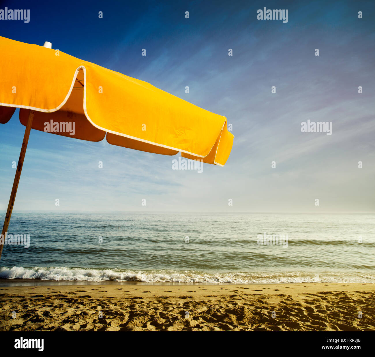 Yellow parasol on the sandy beach Stock Photo - Alamy