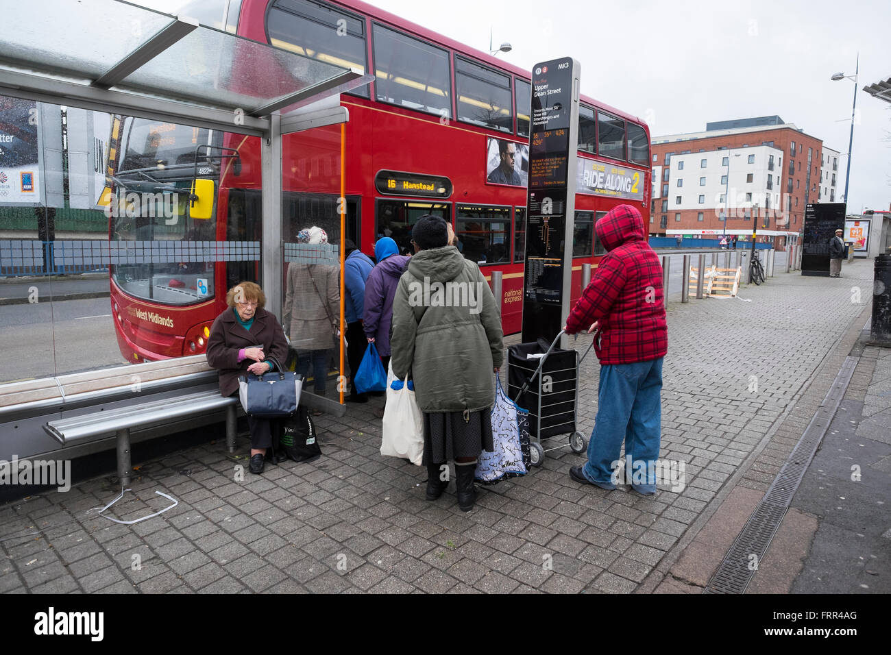 Passengers queuing for a double deck bus at Birmingham Bullring, West ...