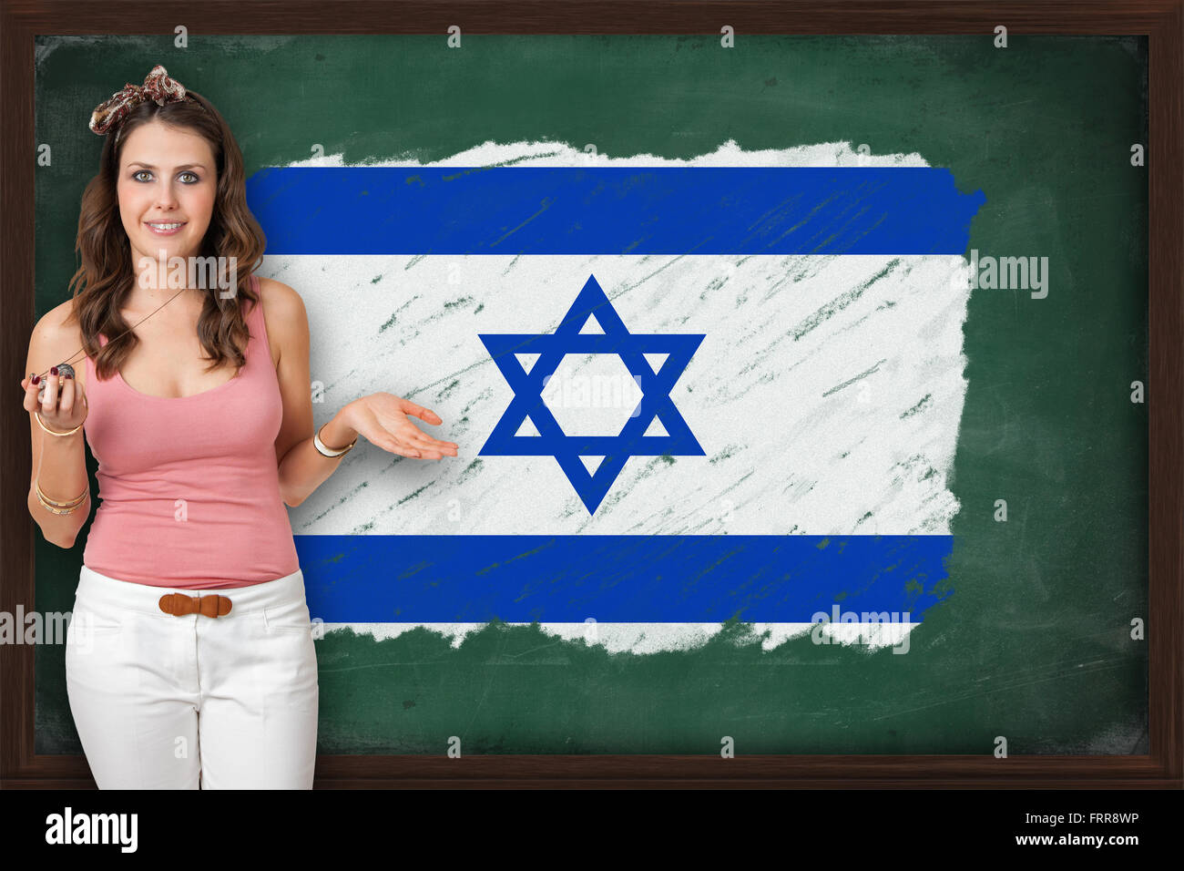 Beautiful and smiling woman showing flag of Israel on blackboard ...