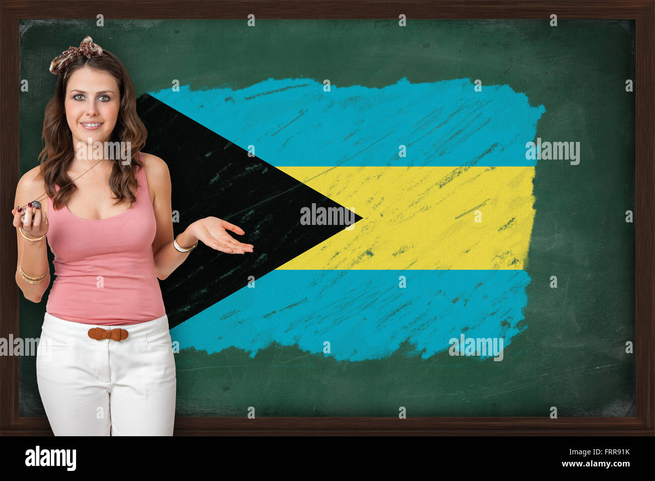 Beautiful and smiling woman showing flag of The Bahamas on blackboard ...