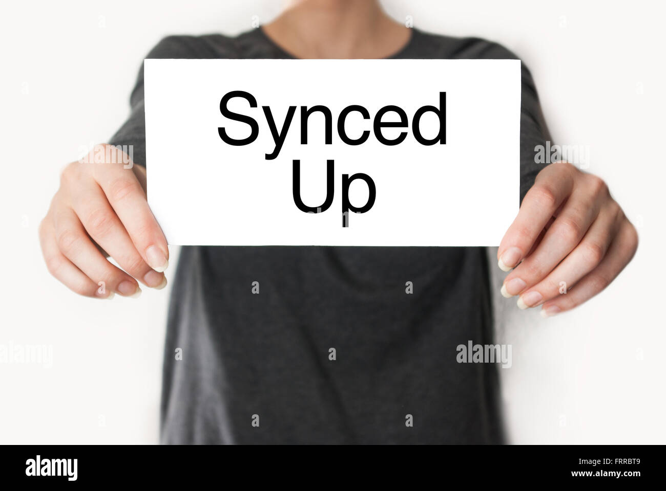 Synced Up. Female in black shirt showing or holding a card Stock Photo ...