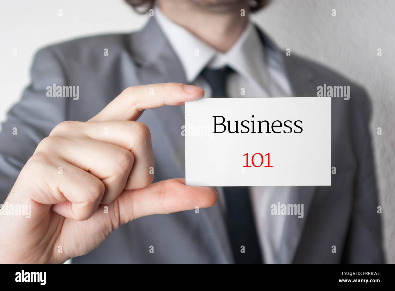 Business 101. Businessman in suit with a black tie showing or holding ...