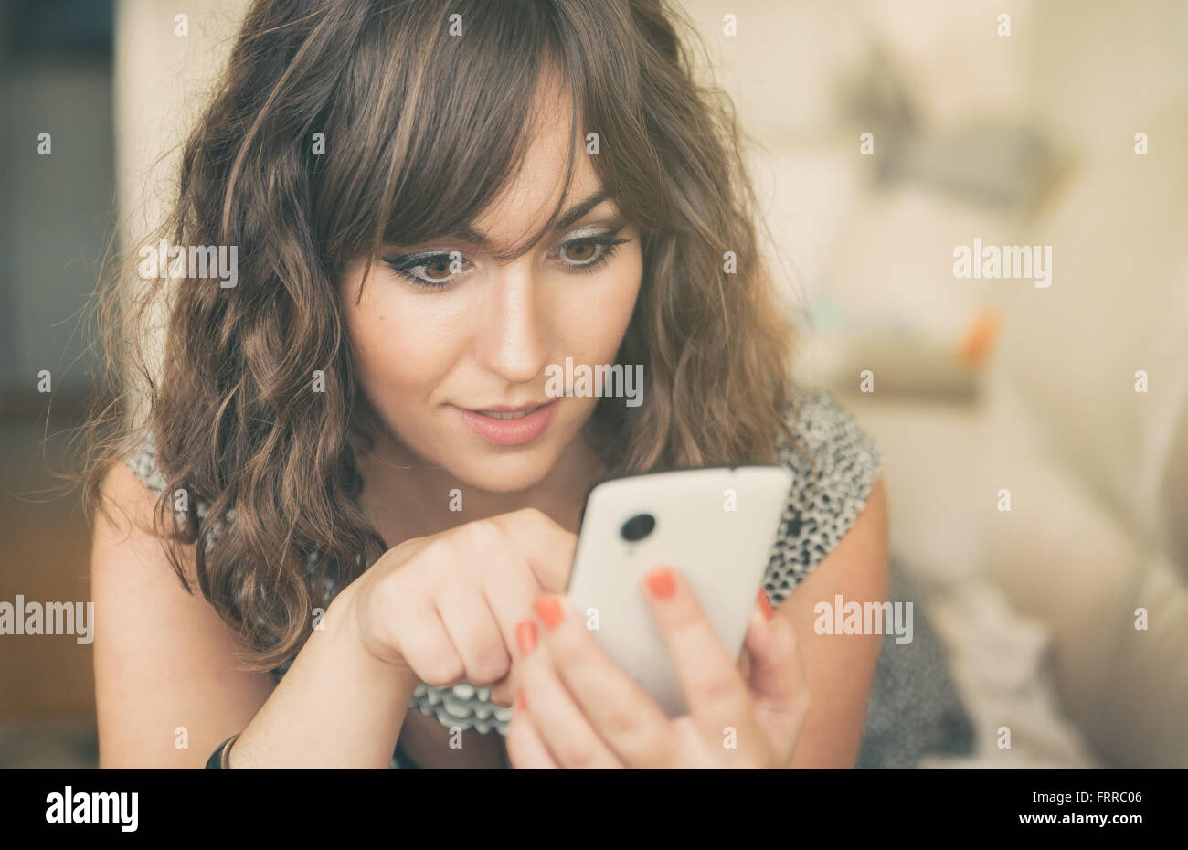 Young woman texting on her mobile phone concentrating as she enters ...