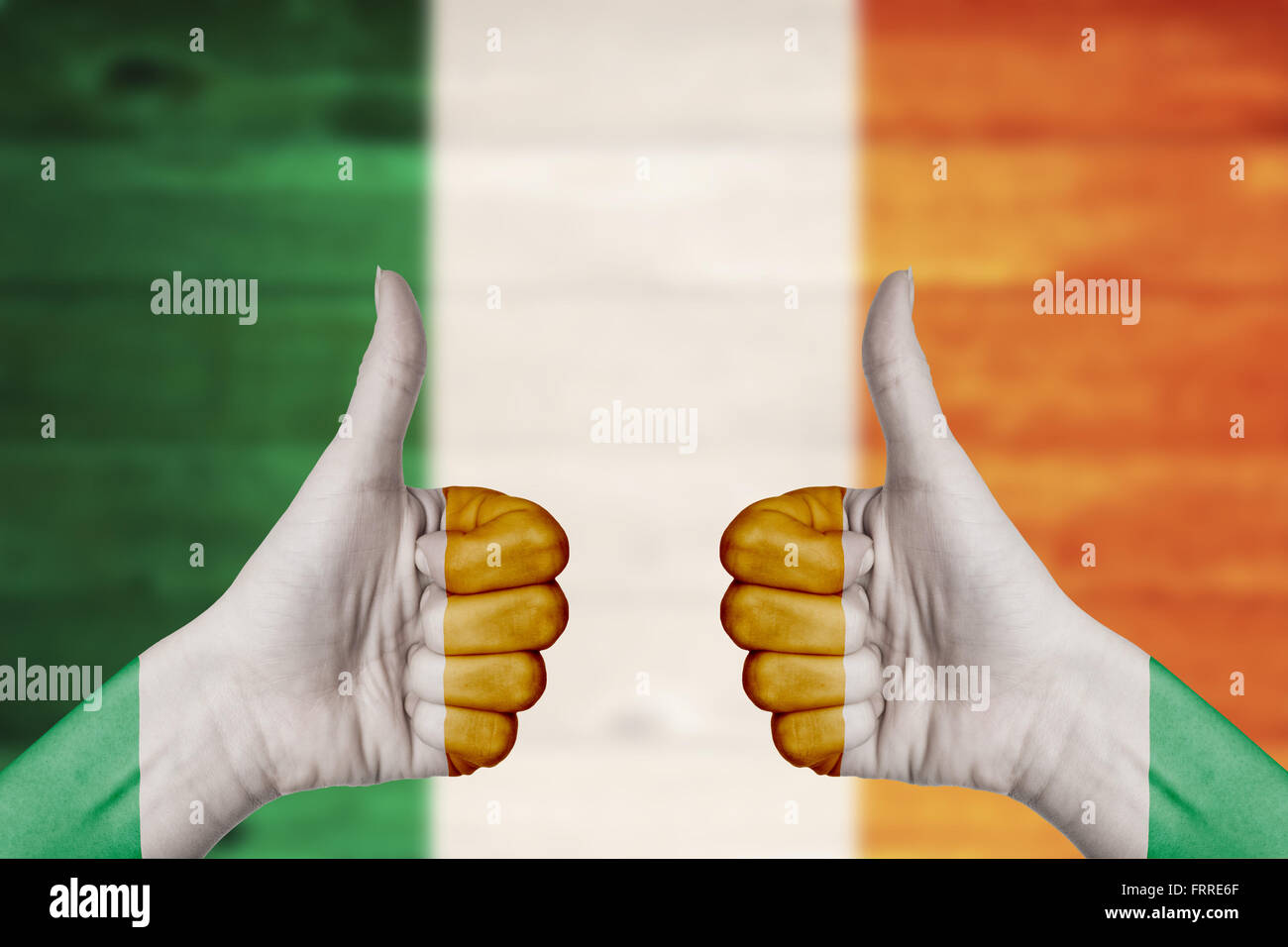 Ireland flag painted on female hands thumbs up with blurry wooden ...