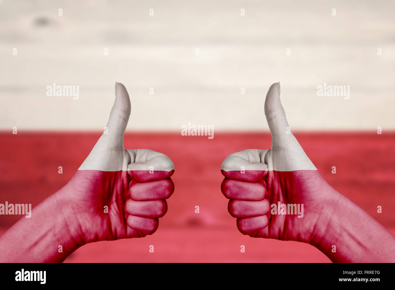 Poland flag painted on female hands thumbs up with blurry wooden ...