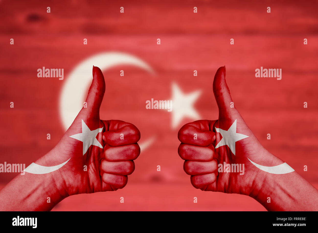 Turkey flag painted on female hands thumbs up with blurry wooden ...