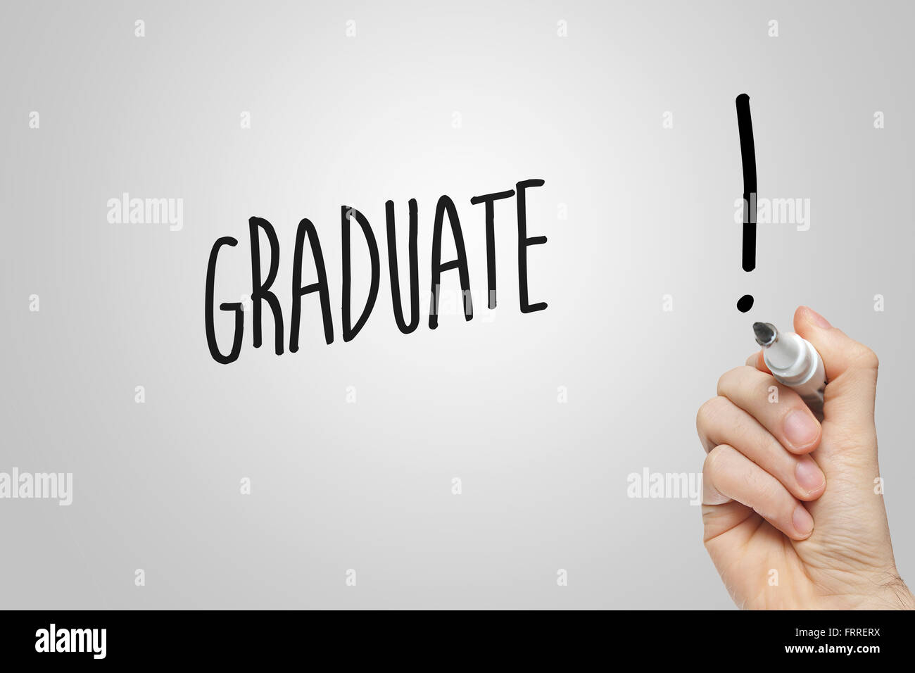 Hand writing graduate on grey background Stock Photo - Alamy