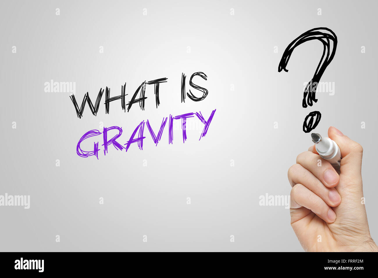 Hand writing what is gravity on grey background Stock Photo - Alamy