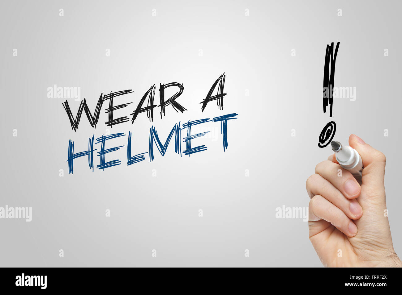 Hand writing wear a helmet on grey background Stock Photo - Alamy