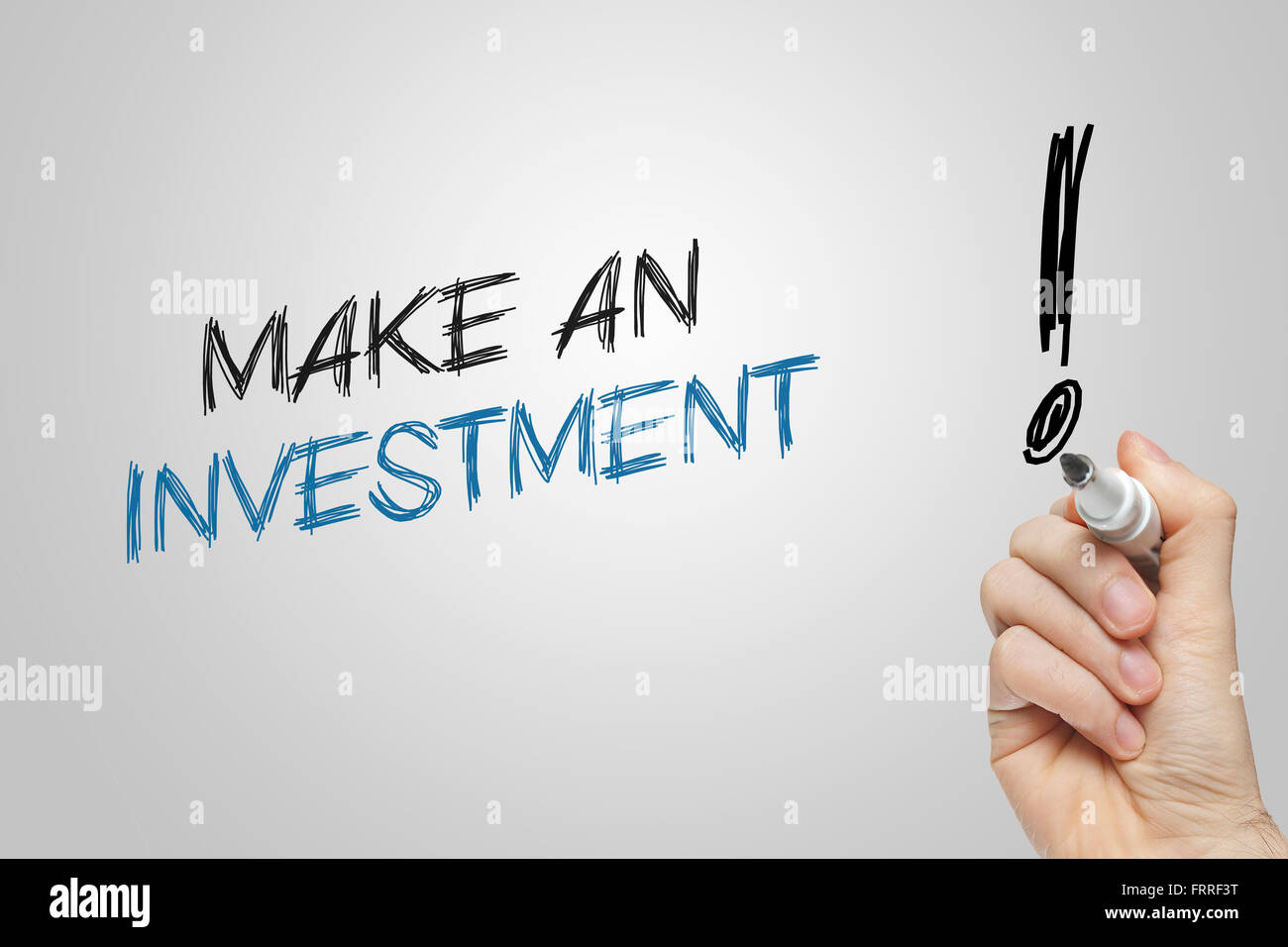 Hand writing make an investment on grey background Stock Photo - Alamy