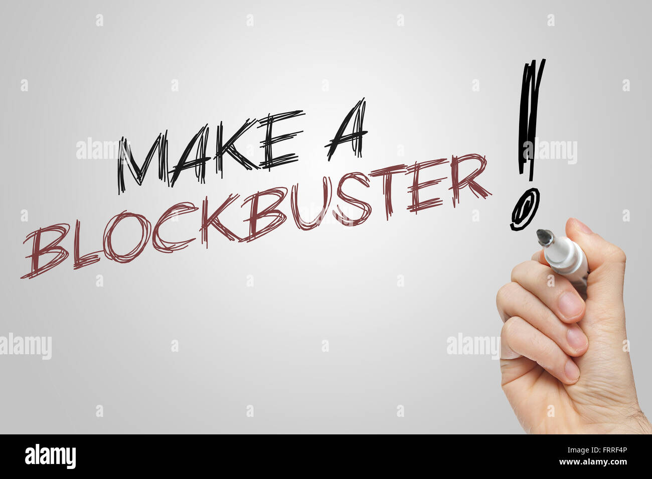 Hand writing make a blockbuster on grey background Stock Photo - Alamy