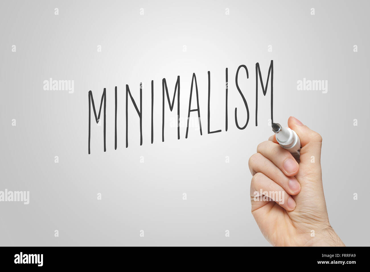 Hand writing minimalism on grey background Stock Photo - Alamy