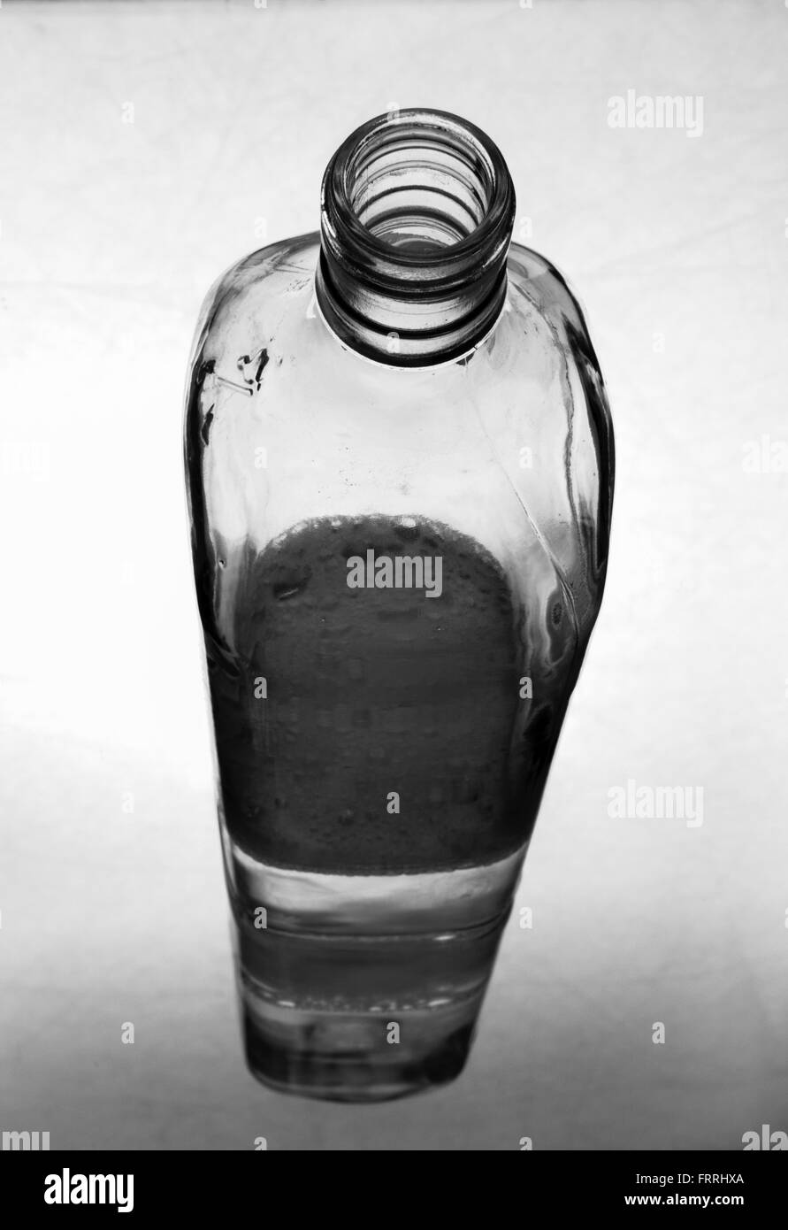 Glass bottle half filled with water on mirror Stock Photo - Alamy