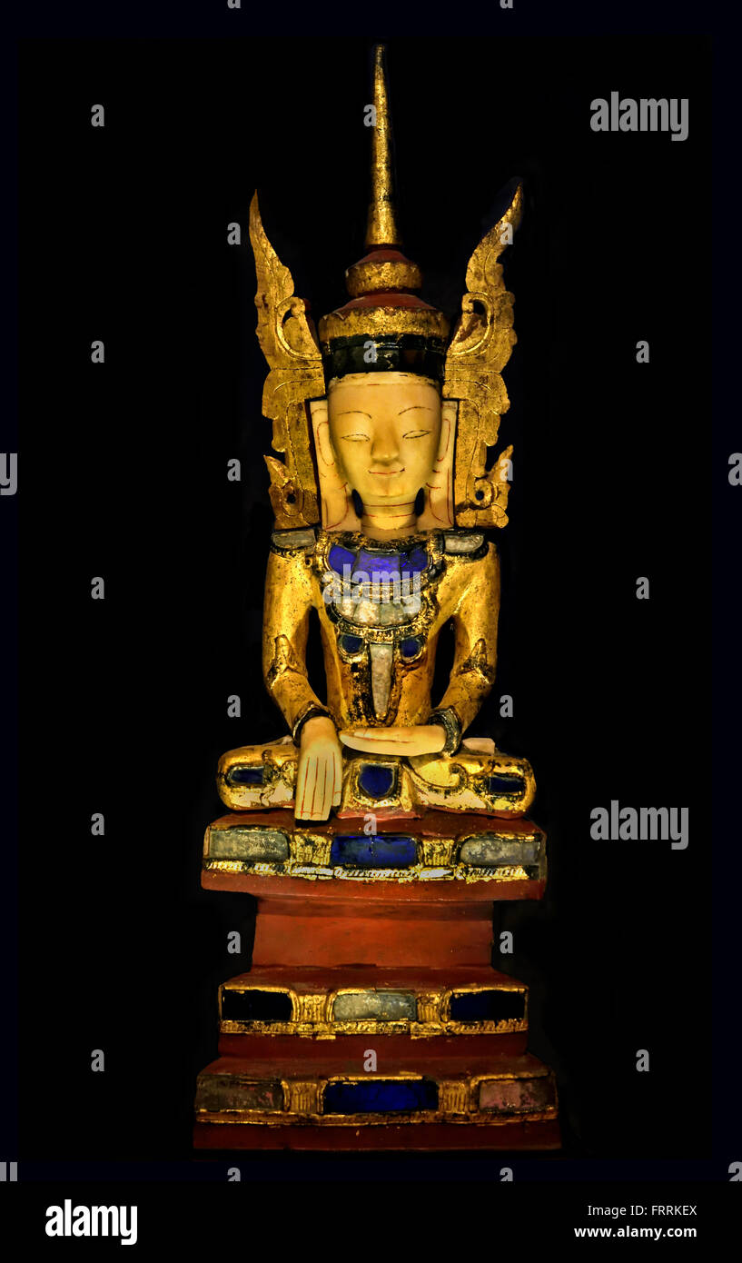 Buddha in royal finery, sitting cross-legged on a high and richly ...