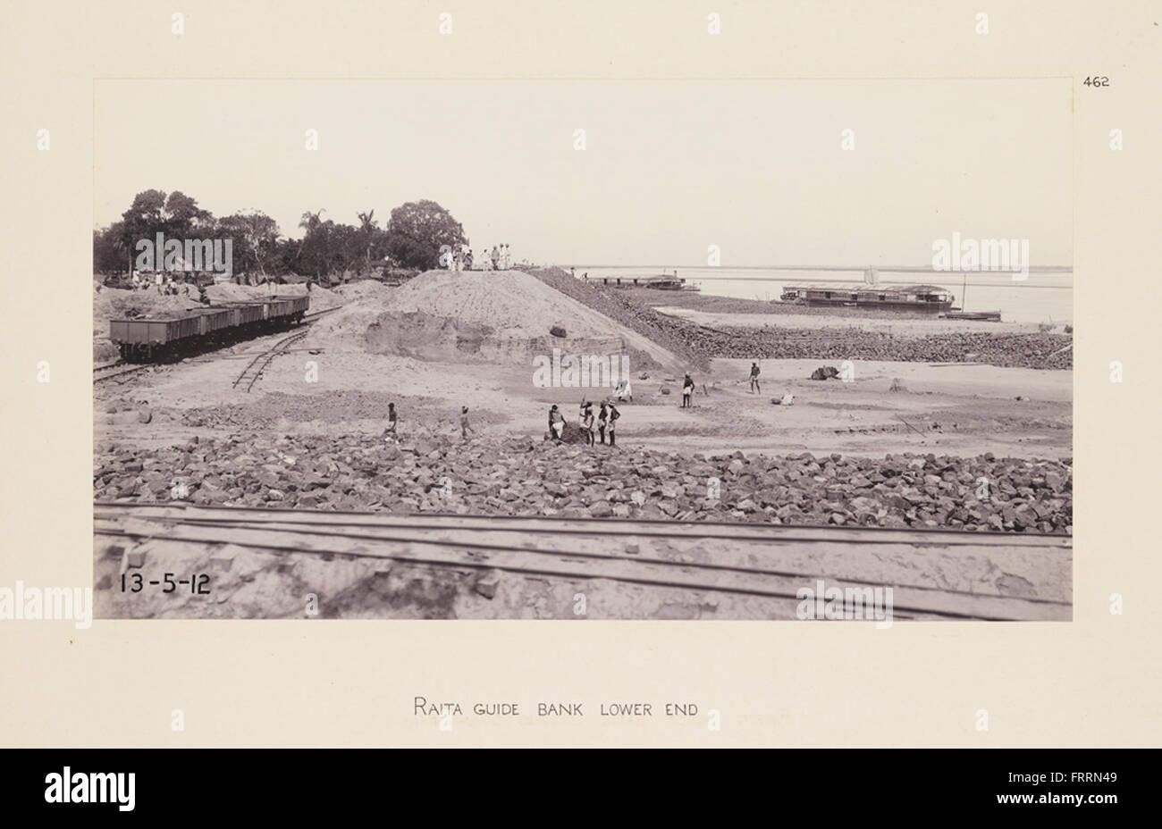 The image depicts the construction of a railroad bridge, focusing on ...