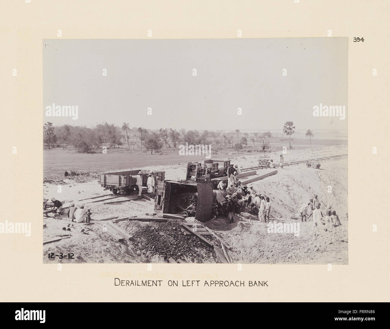 The photograph shows the aftermath of a railroad derailment on the left ...