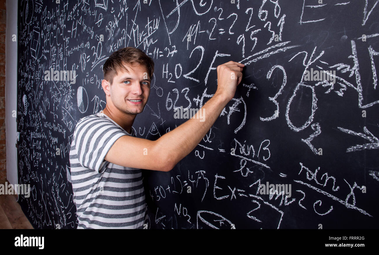 Student writing on big blackboard with mathematical symbols Stock Photo ...