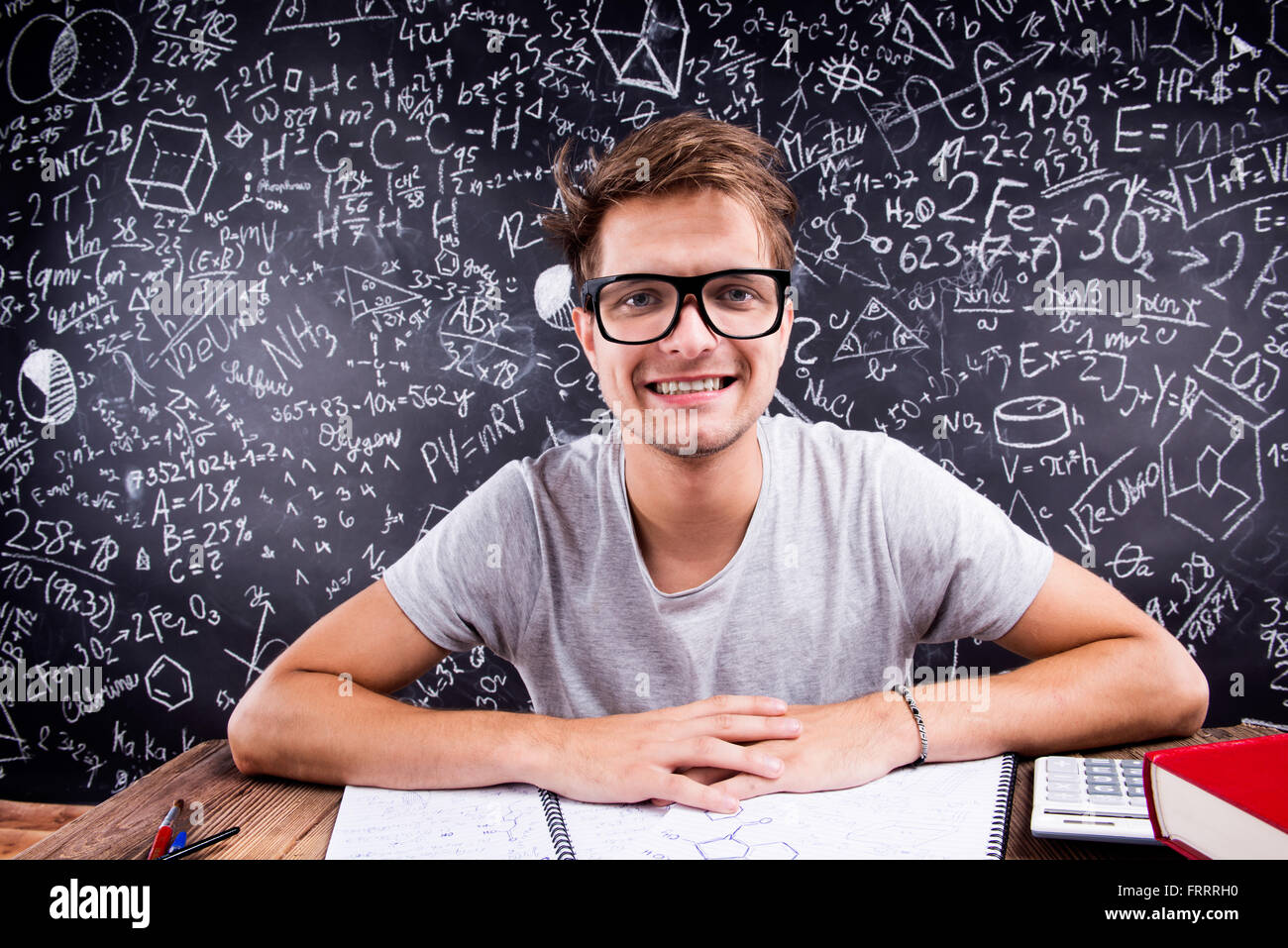 Hipster student doing his homework against a big blackboard Stock Photo ...
