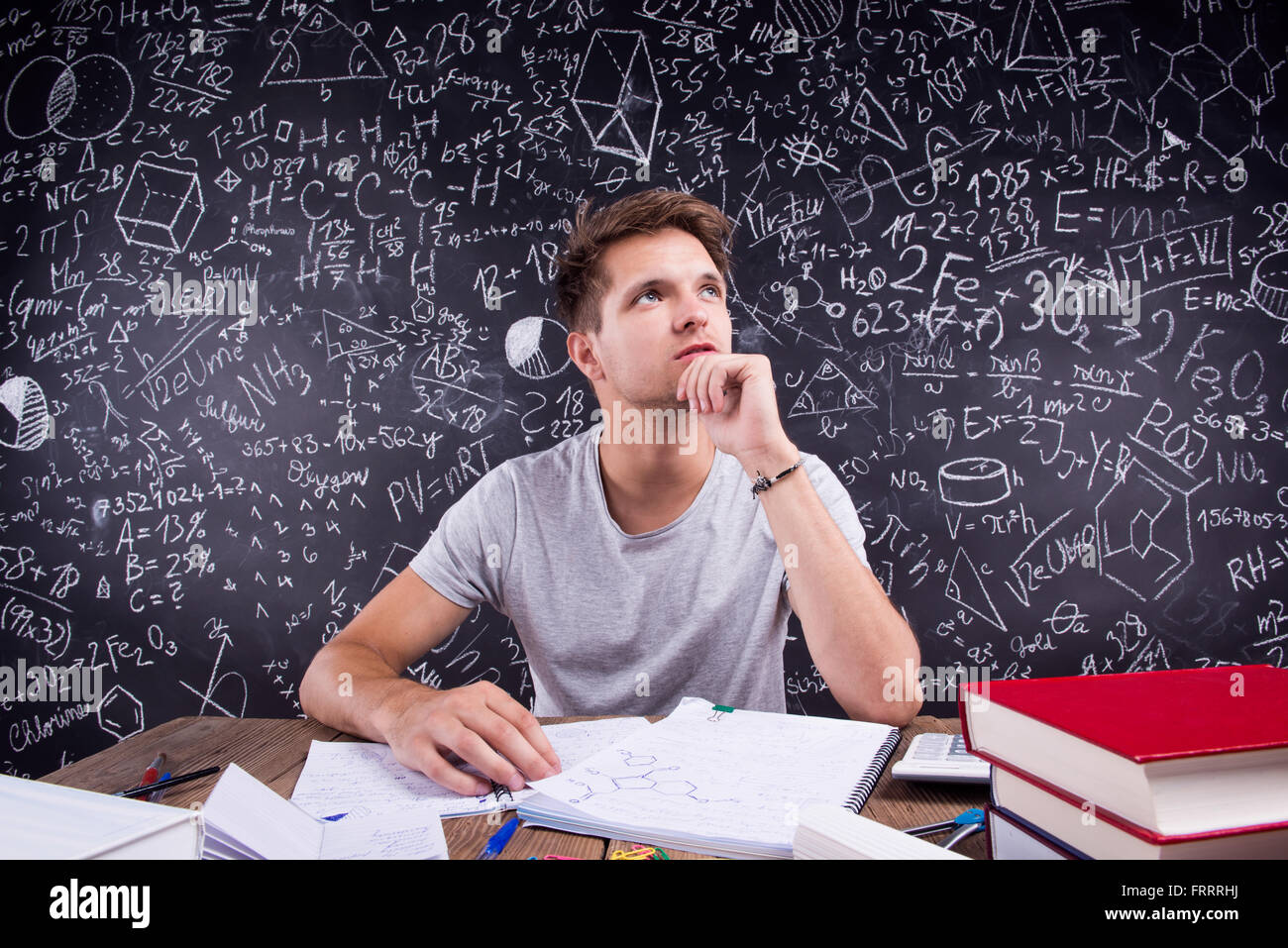 Hipster student doing his homework against a big blackboard Stock Photo ...