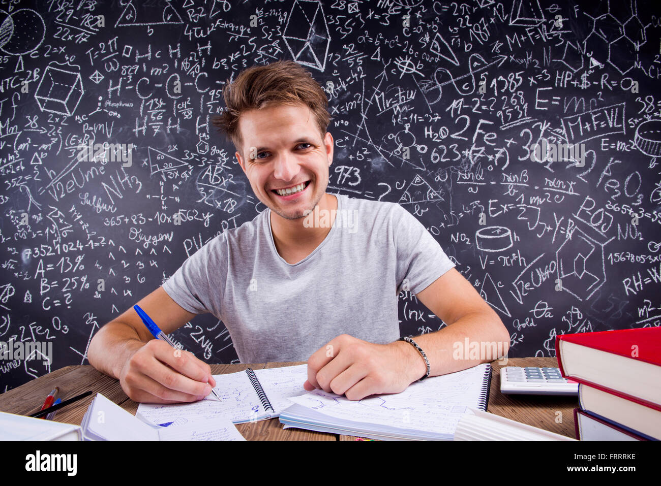 Hipster student doing his homework against a big blackboard Stock Photo ...