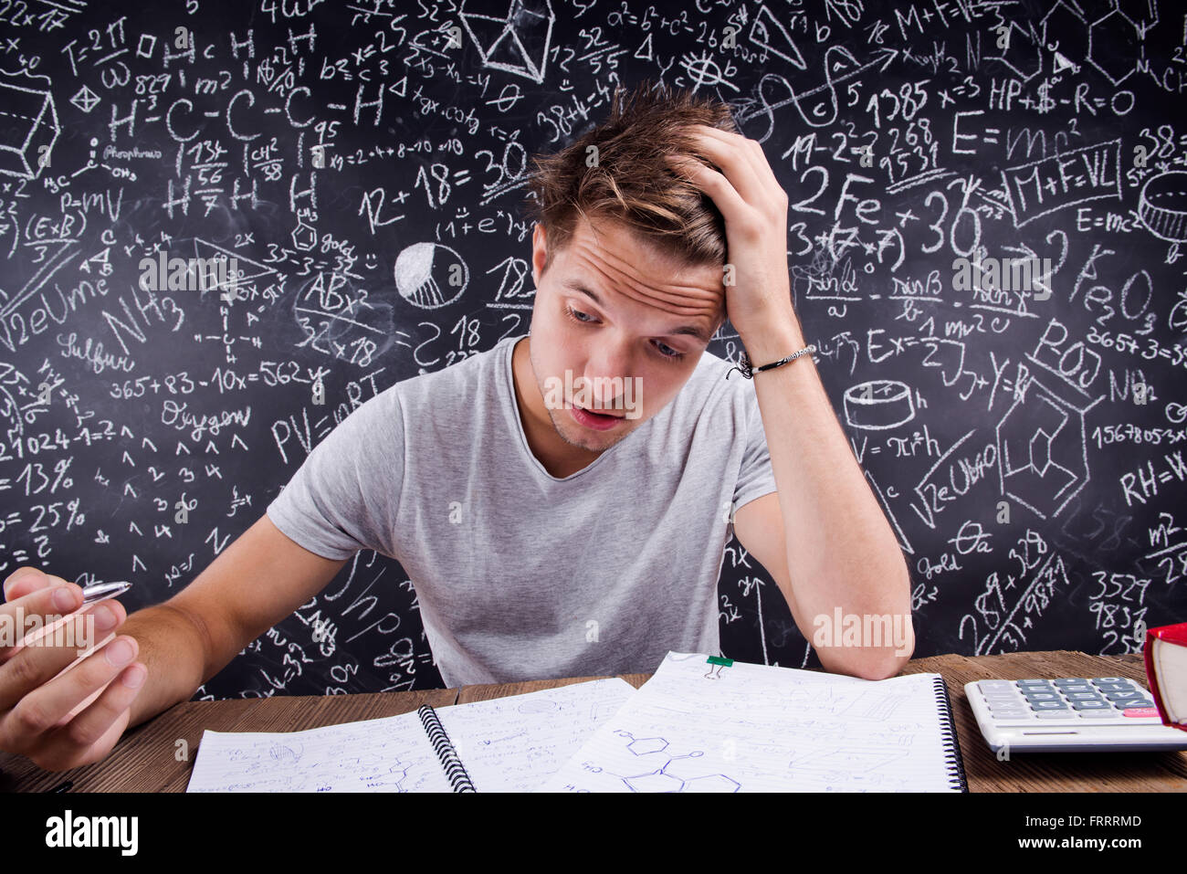 Hipster student doing his homework against a big blackboard Stock Photo ...