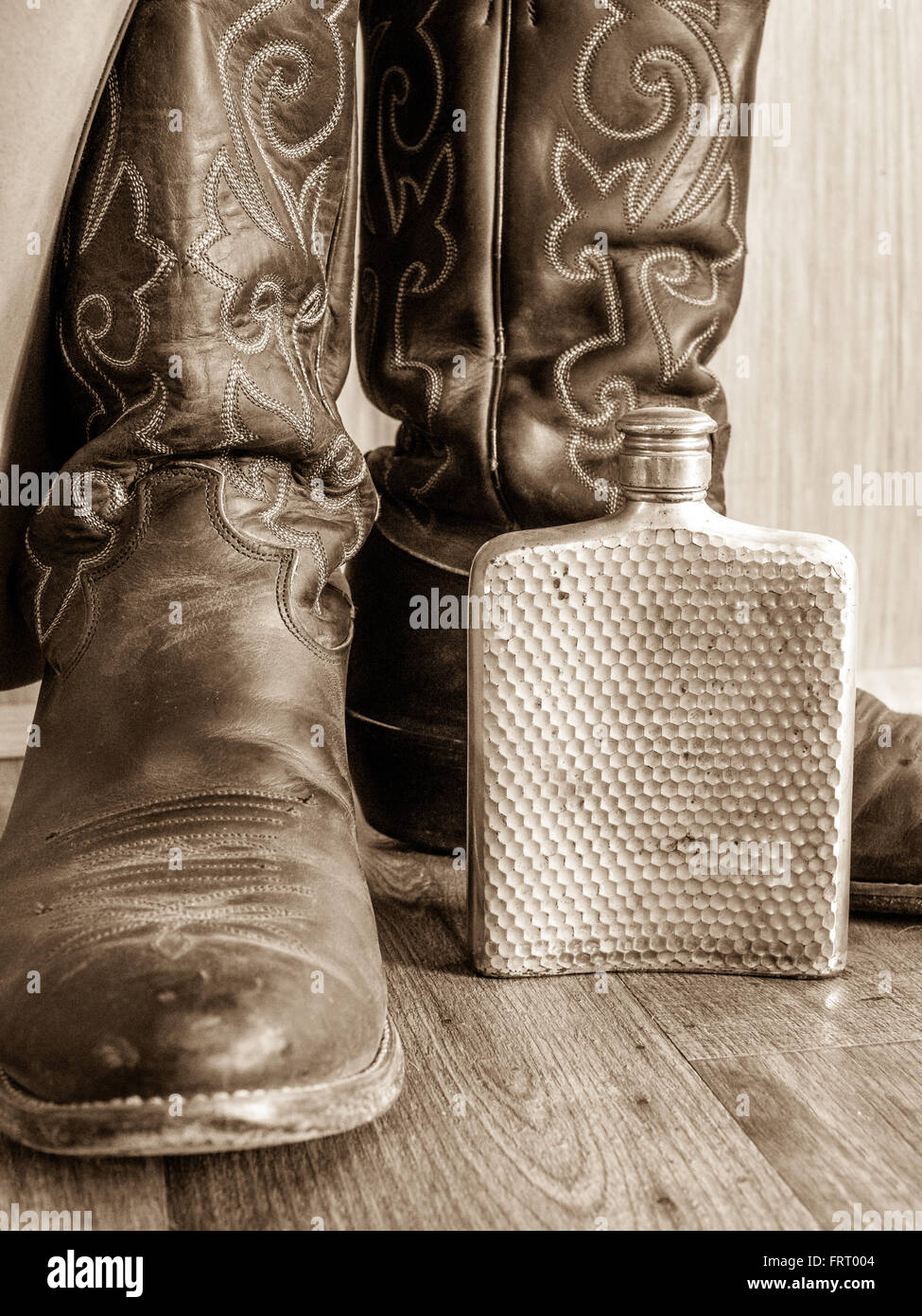 Cowboy boots, flask, wooden floor and background Stock Photo - Alamy