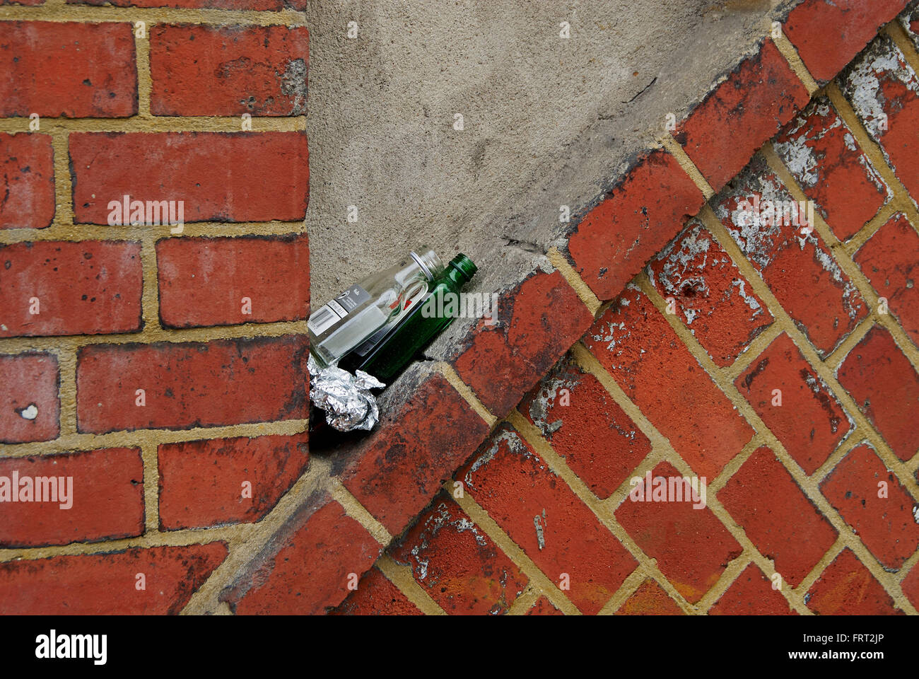 Empty alcohol bottles discarded on a ledge Stock Photo - Alamy