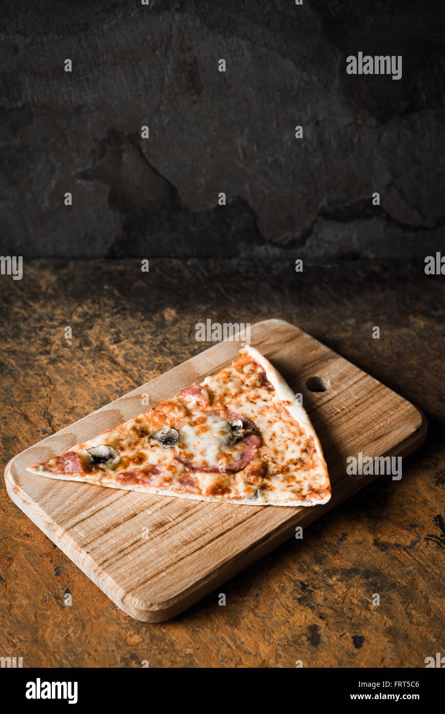 Slice of pizza on the wooden board vertical Stock Photo - Alamy