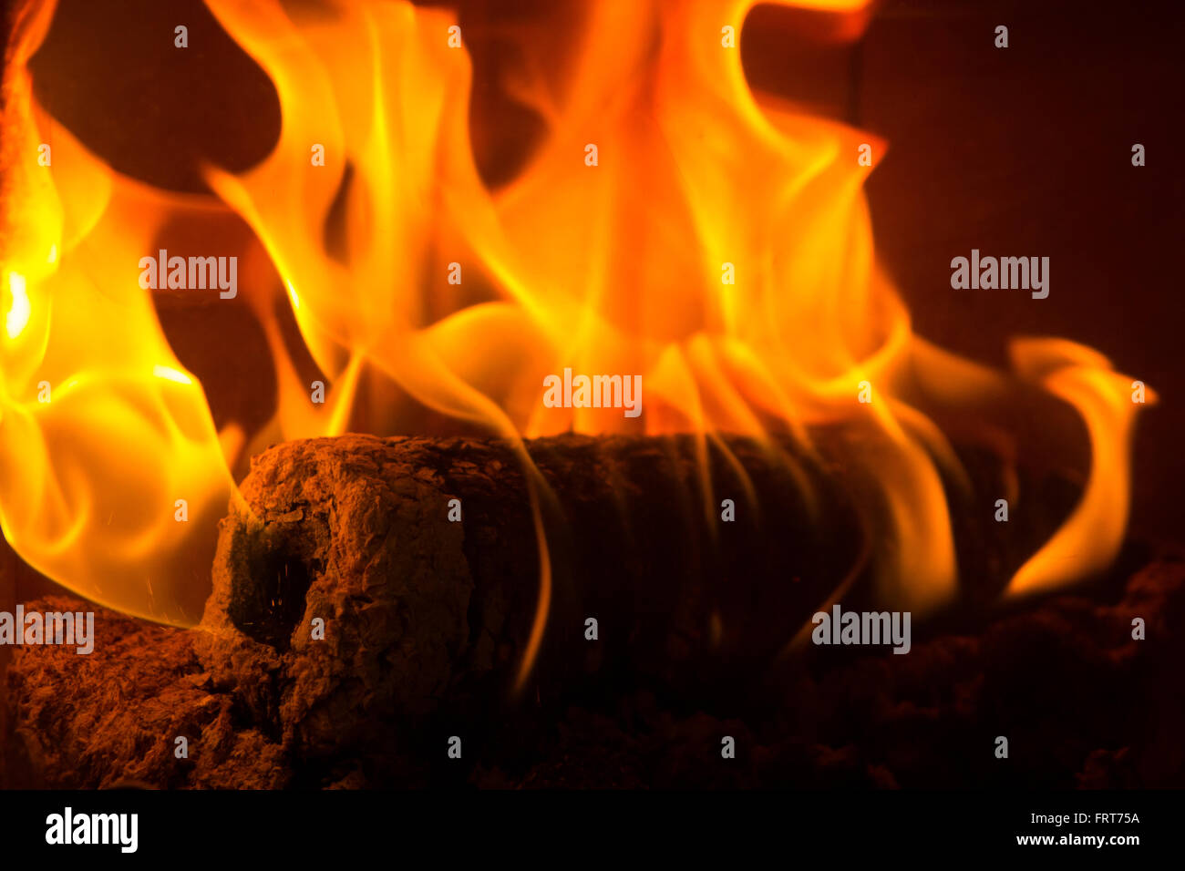 Log on fire burning billets in fireplace Stock Photo - Alamy