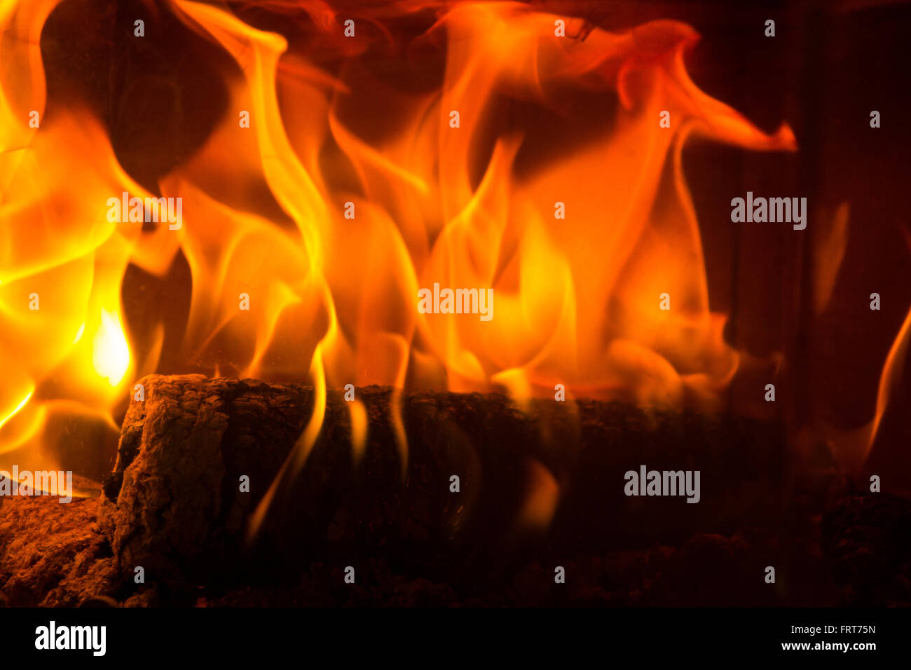 Log on fire burning billets in fireplace Stock Photo - Alamy