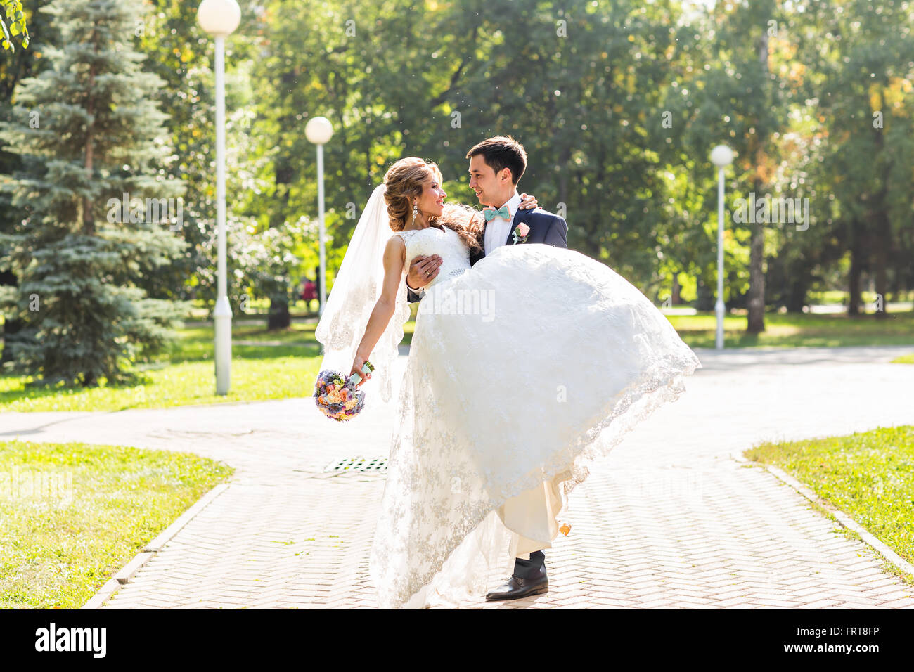 wedding couple hugging, the bride holding a bouquet of flowers, groom ...