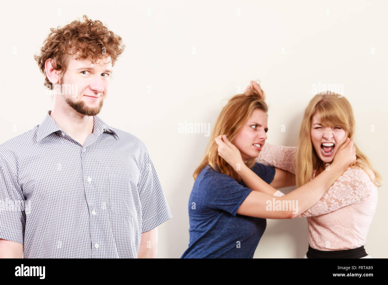 Aggressive mad women fighting over man. Jealous girls wooing guy ...