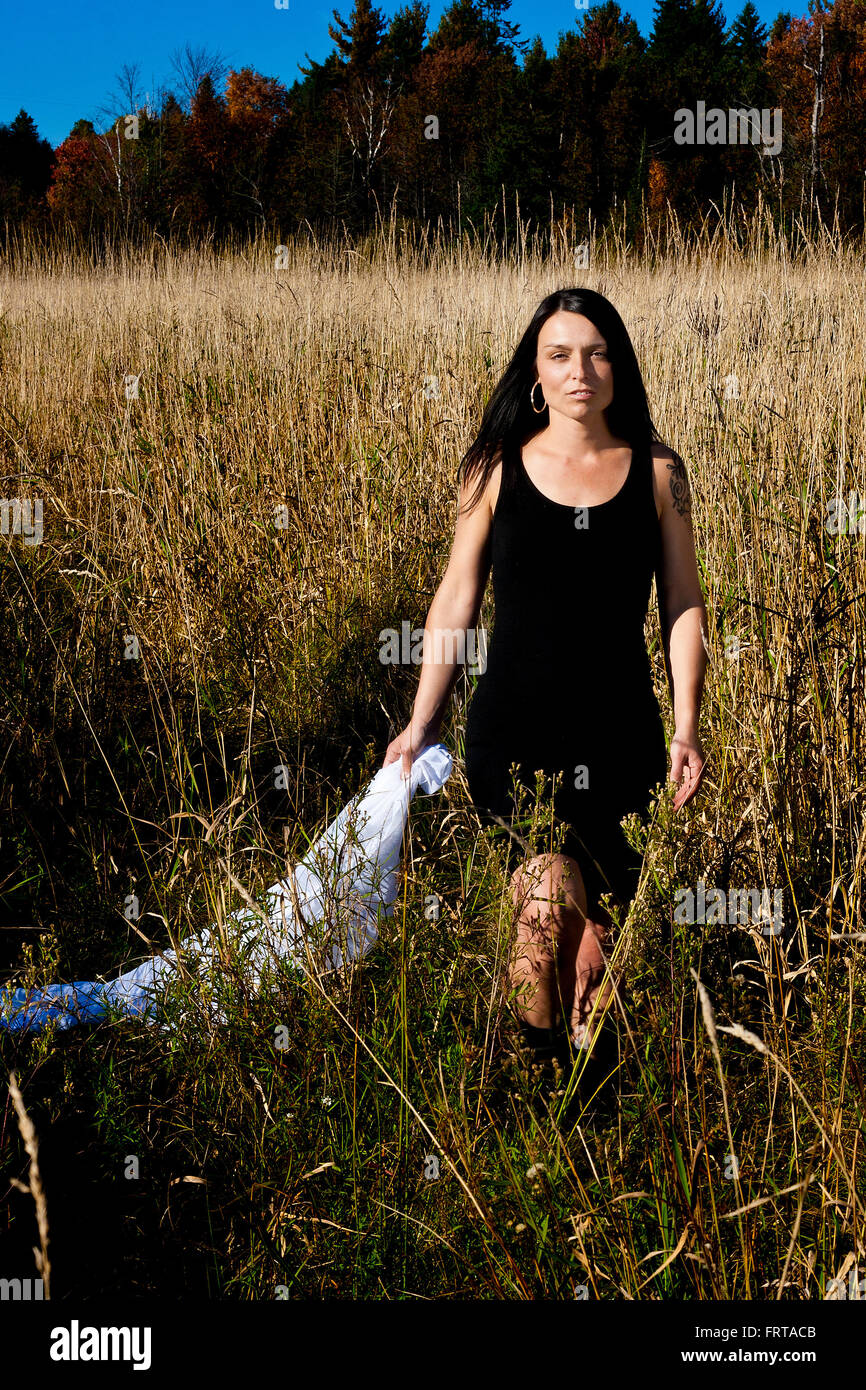 Pretty and petite young woman in a black dress Stock Photo - Alamy