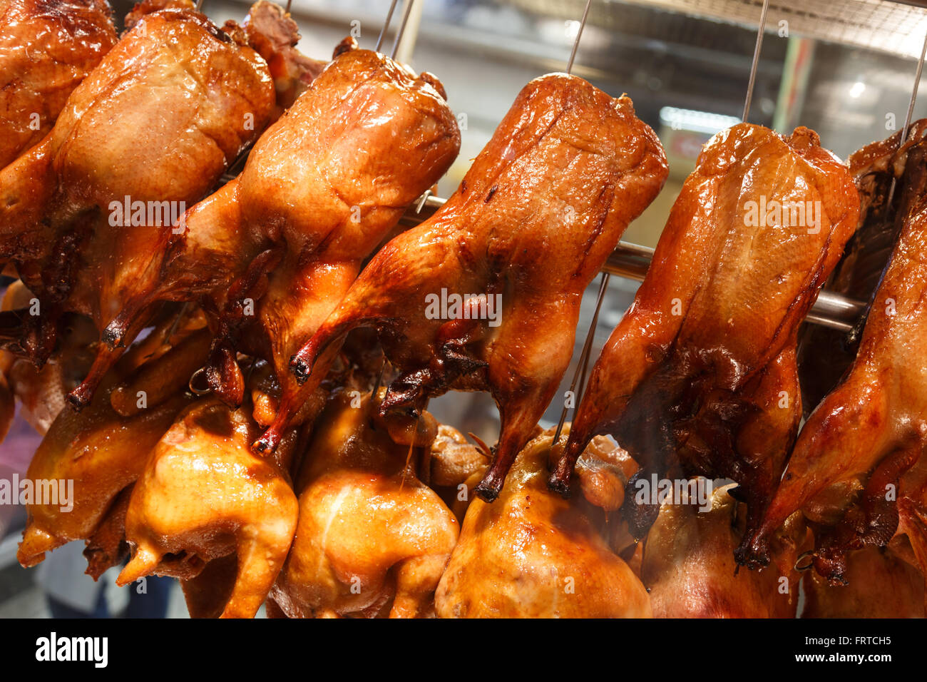 Chinese style cooked duck hanging inside window Stock Photo - Alamy