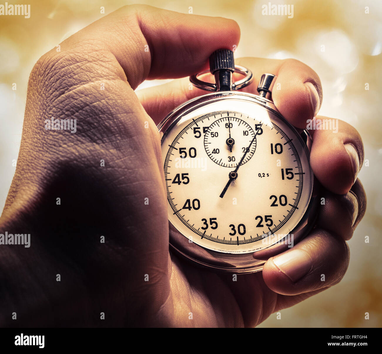 Male hand holding stopwatch in dramatic light Stock Photo - Alamy