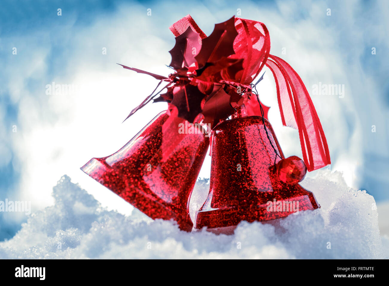 Two christmas bells with red ribbon on snow background Stock Photo - Alamy