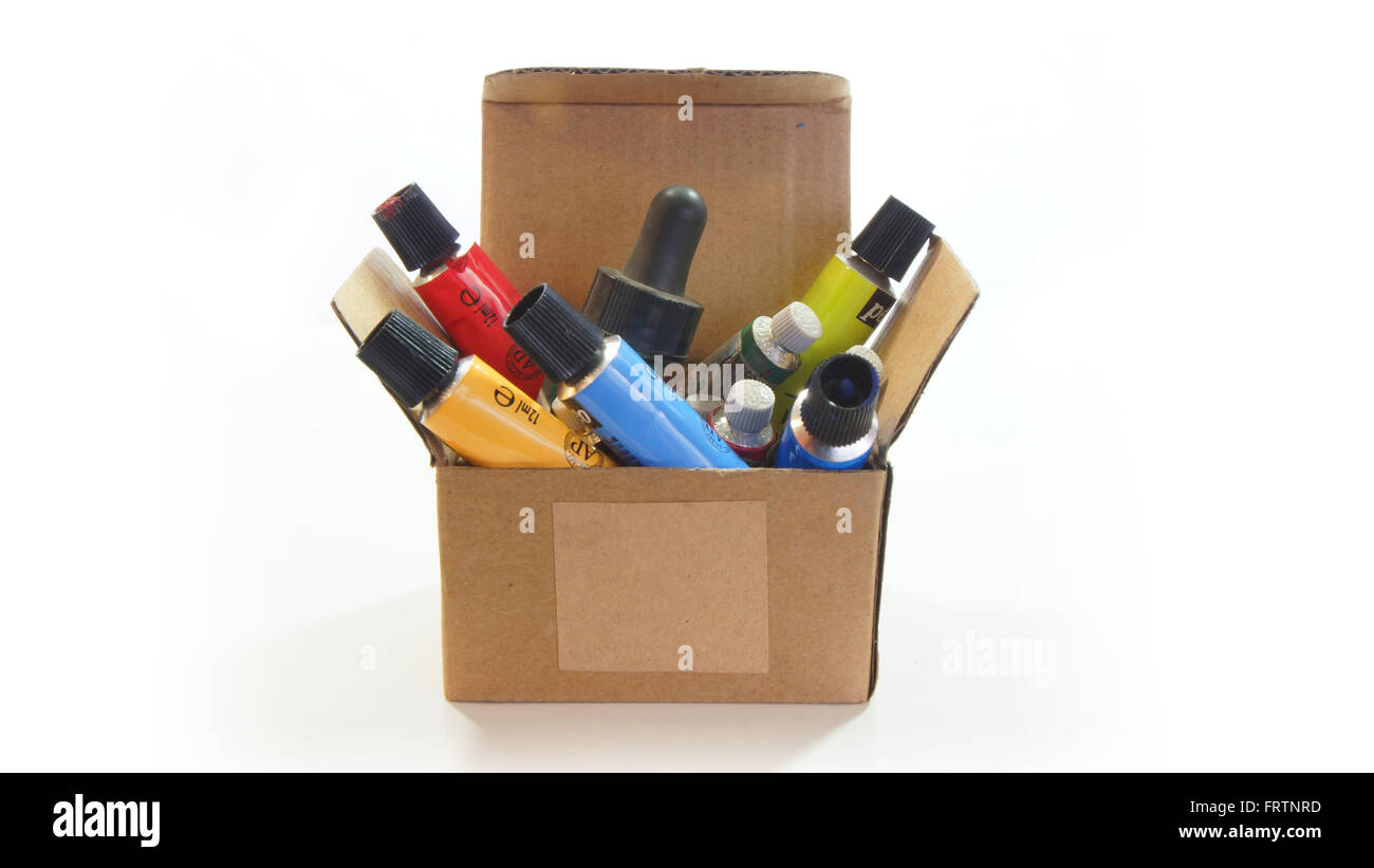 Corrugated cardboard box open with watercolor tubes of different colors ...