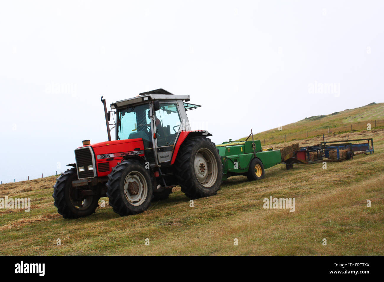 A red tractor cutting grass Stock Photo - Alamy